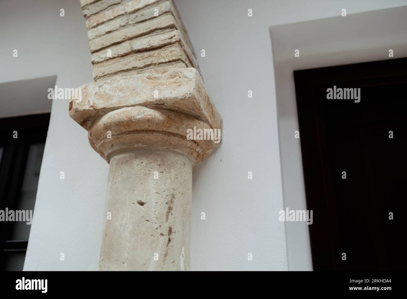 A tall, white concrete column featuring decorative painted detailing ...