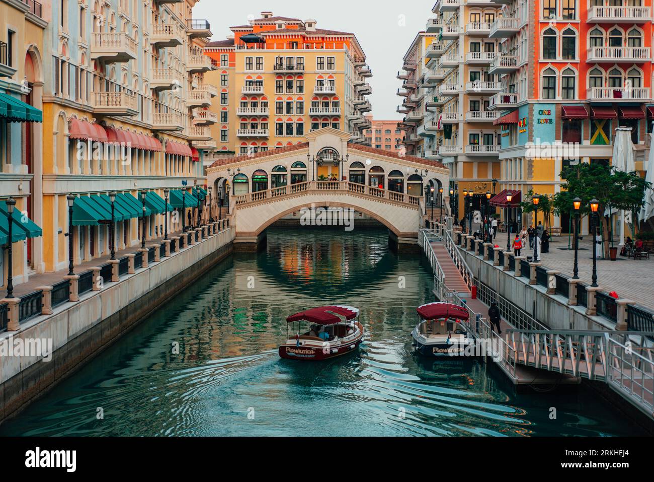 The boats float underneath a bridge on the breathtaking Pearl of Qatar ...