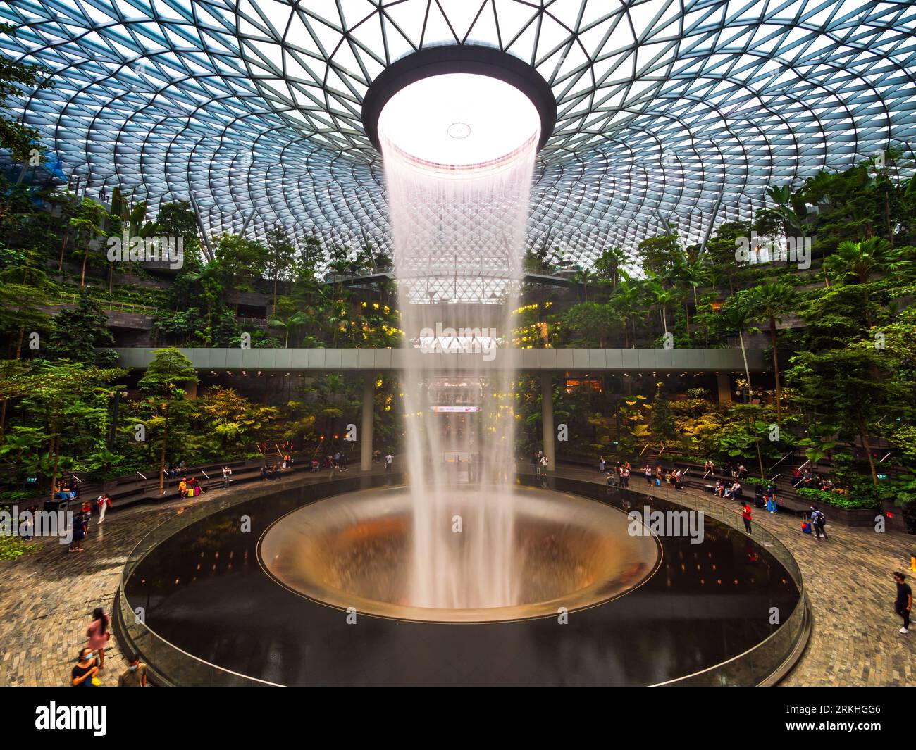 Top view of the indoor waterfall at Jewel and the Skytrain passing the ...