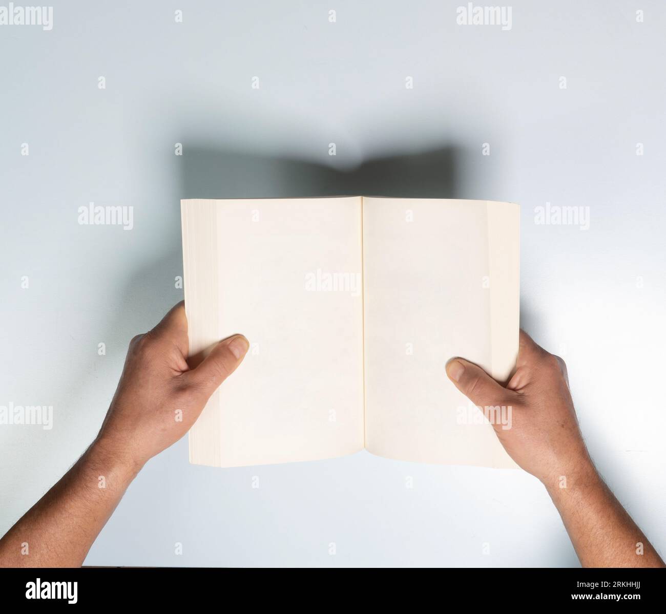 an empty book in the hands of a man on a white background Stock Photo ...