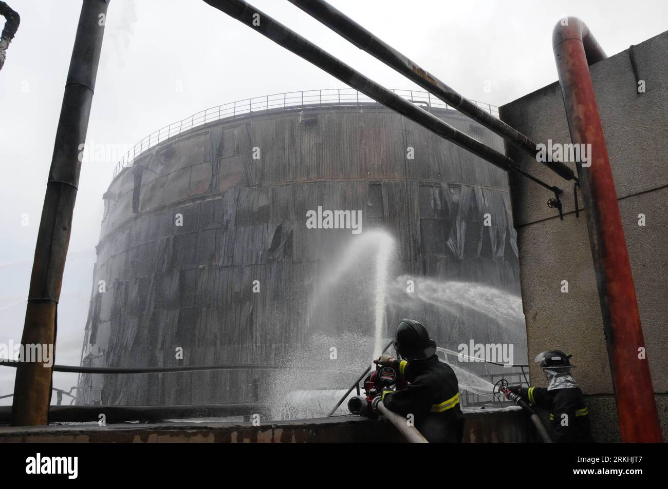 Three firefighters extinguish fire tank hi-res stock photography and ...