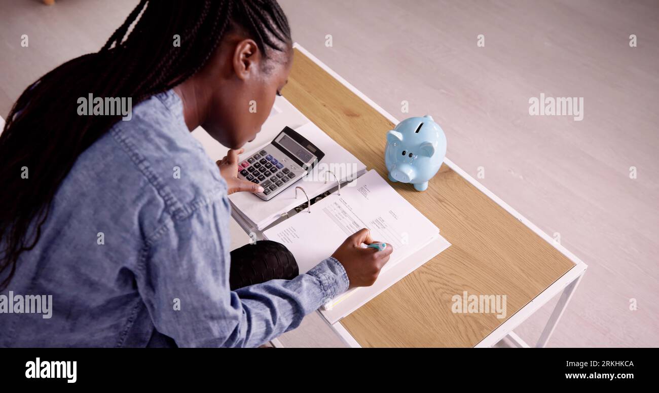 Young African Woman Calculating Invoice With Calculator Stock Photo - Alamy