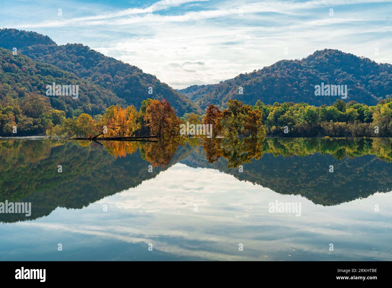 A landscape of golden fall foliage amidst a beautiful sunset backdrop ...