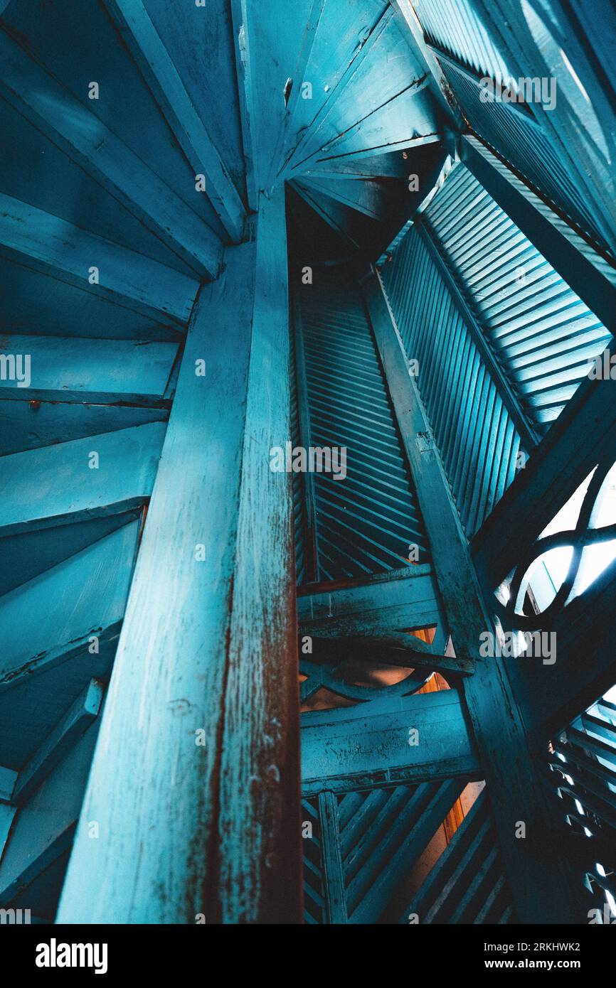 A low-angle shot of a vintage blue spiral staircase, crafted from ...