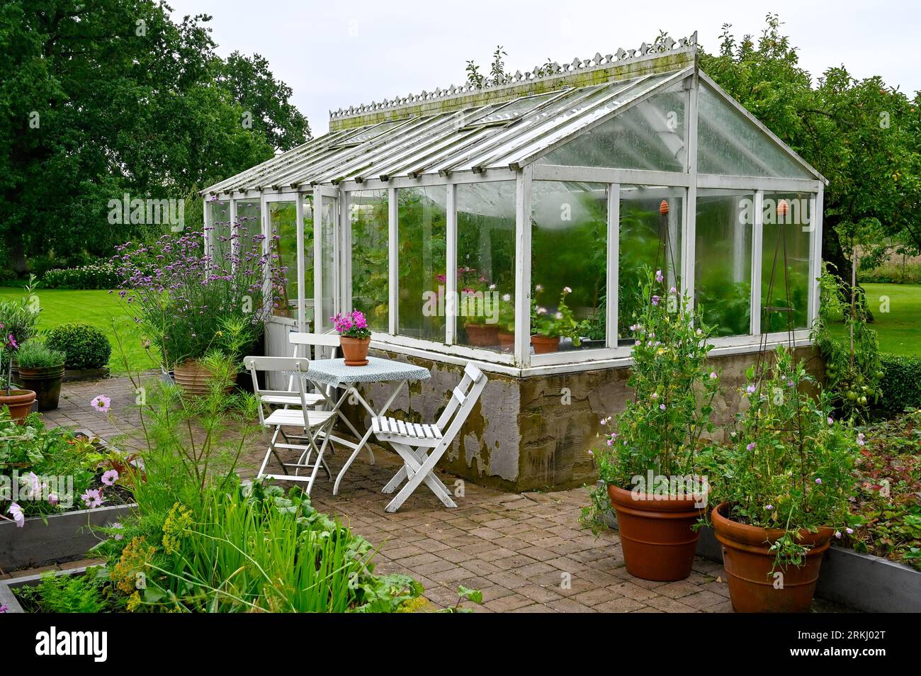 Seating area outside beautiful home made green house Stock Photo - Alamy
