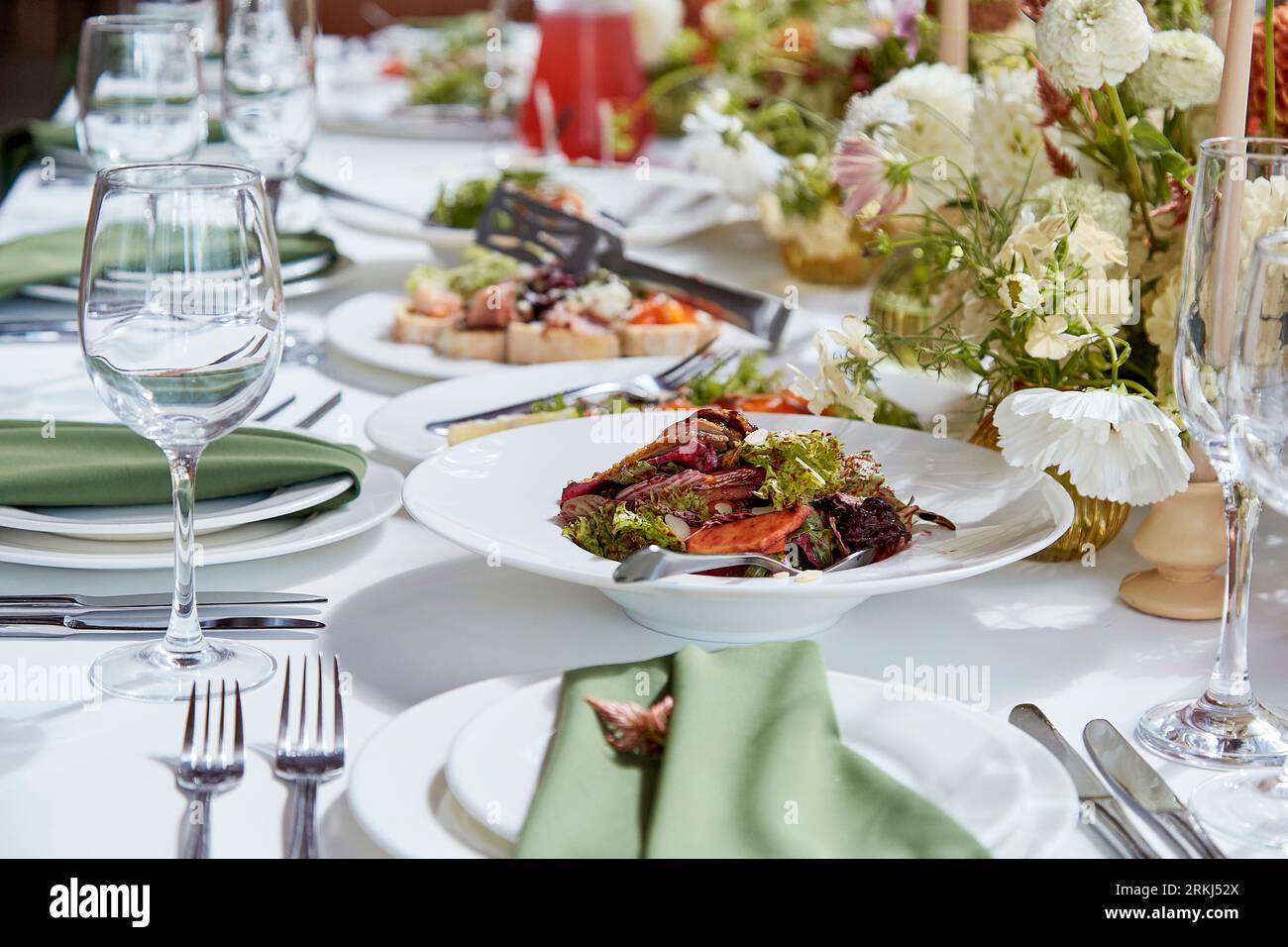 Graceful aesthetics table setting, arranged flowers under natural light ...