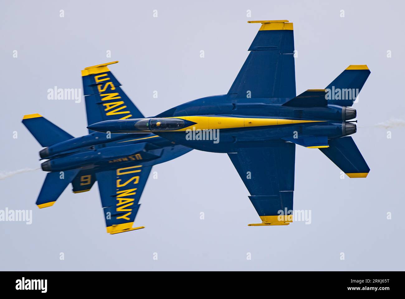 A fighter jet in midflight with wings outstretched against a clear blue ...