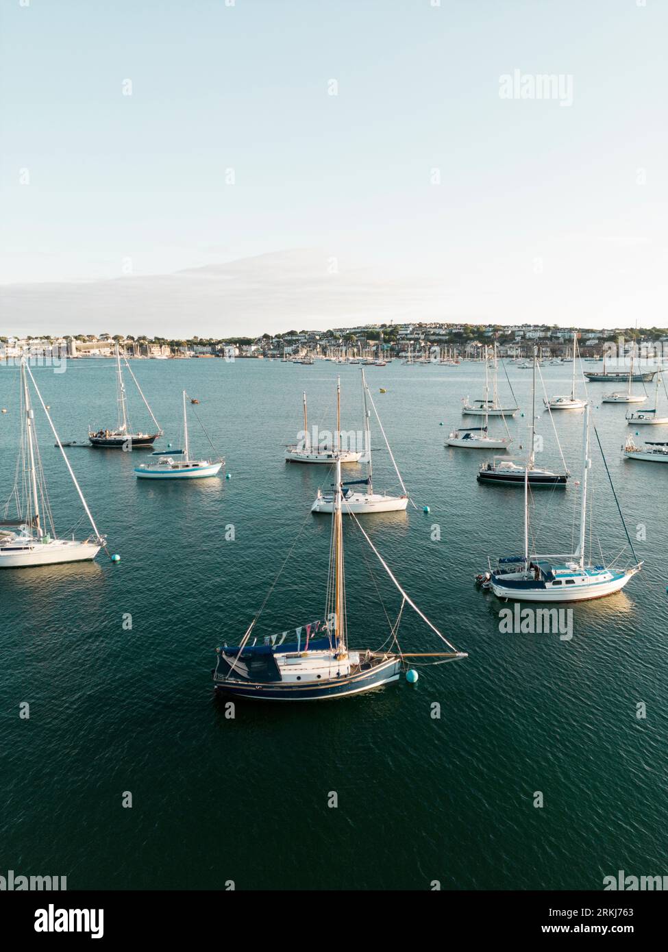 A scenic aerial view of boats floating in the water with the town of ...