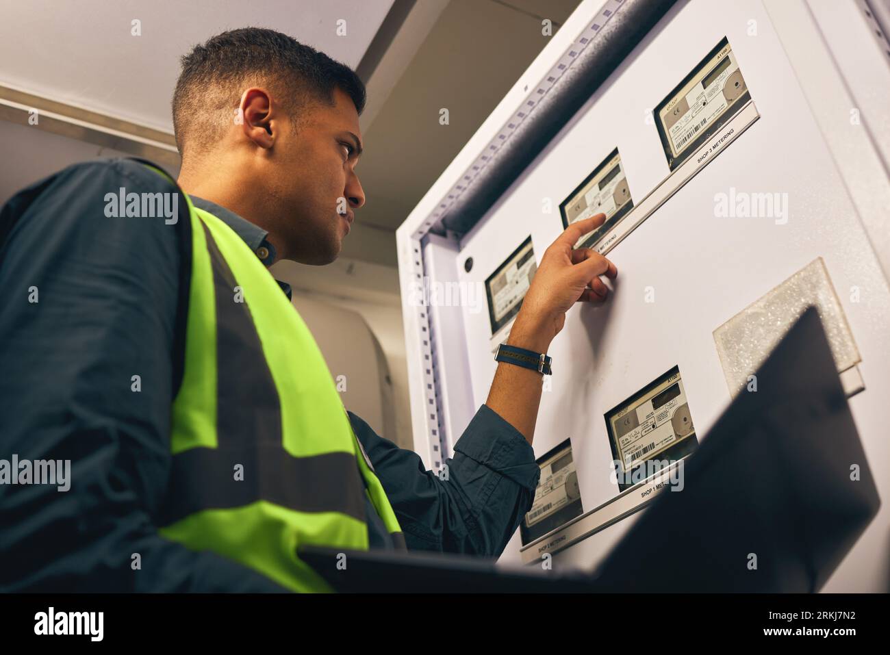 Man, maintenance and control room with laptop, electrician with ...