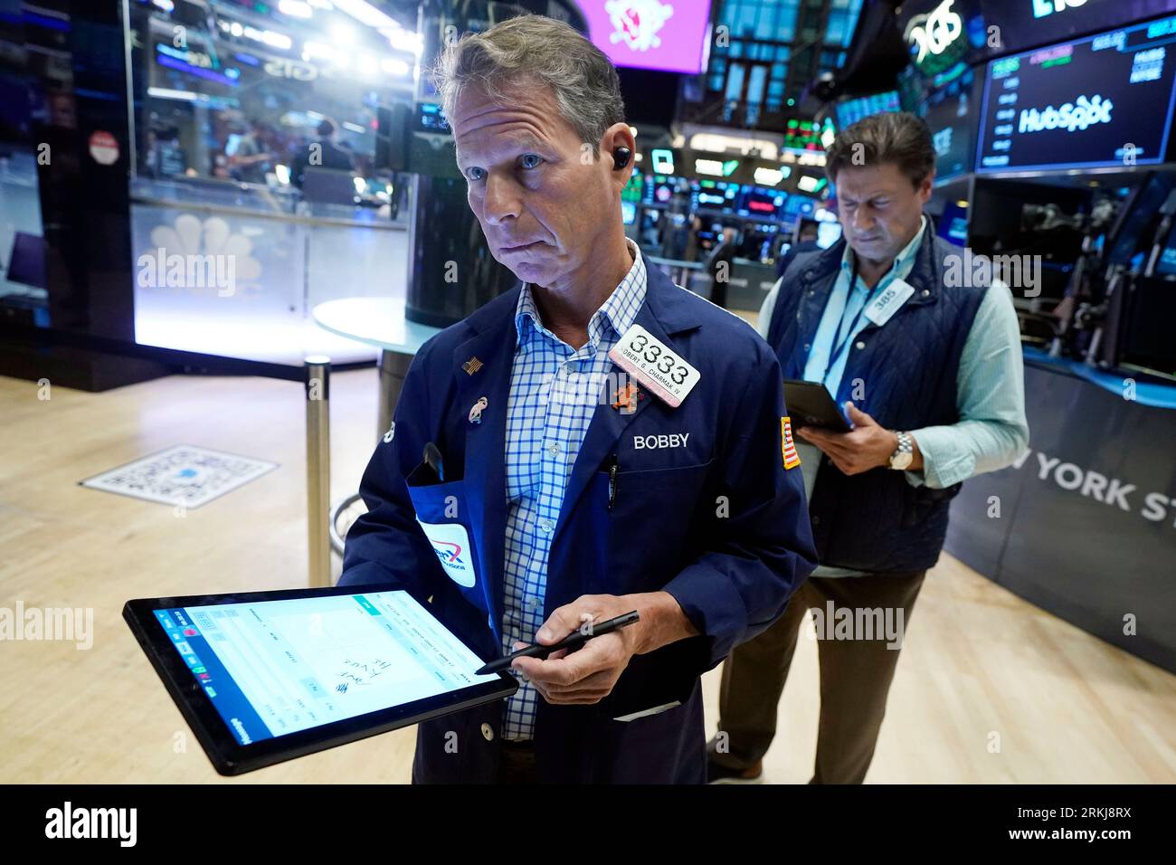 Trader Robert Charmak, left, works on the floor of the New York Stock ...