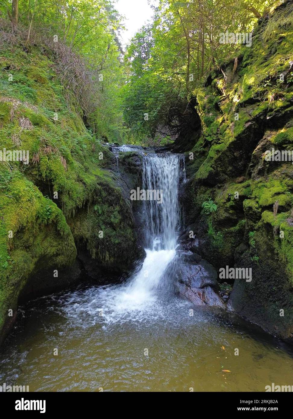 A majestic waterfall cascading down the rocky side of a mountain Stock ...