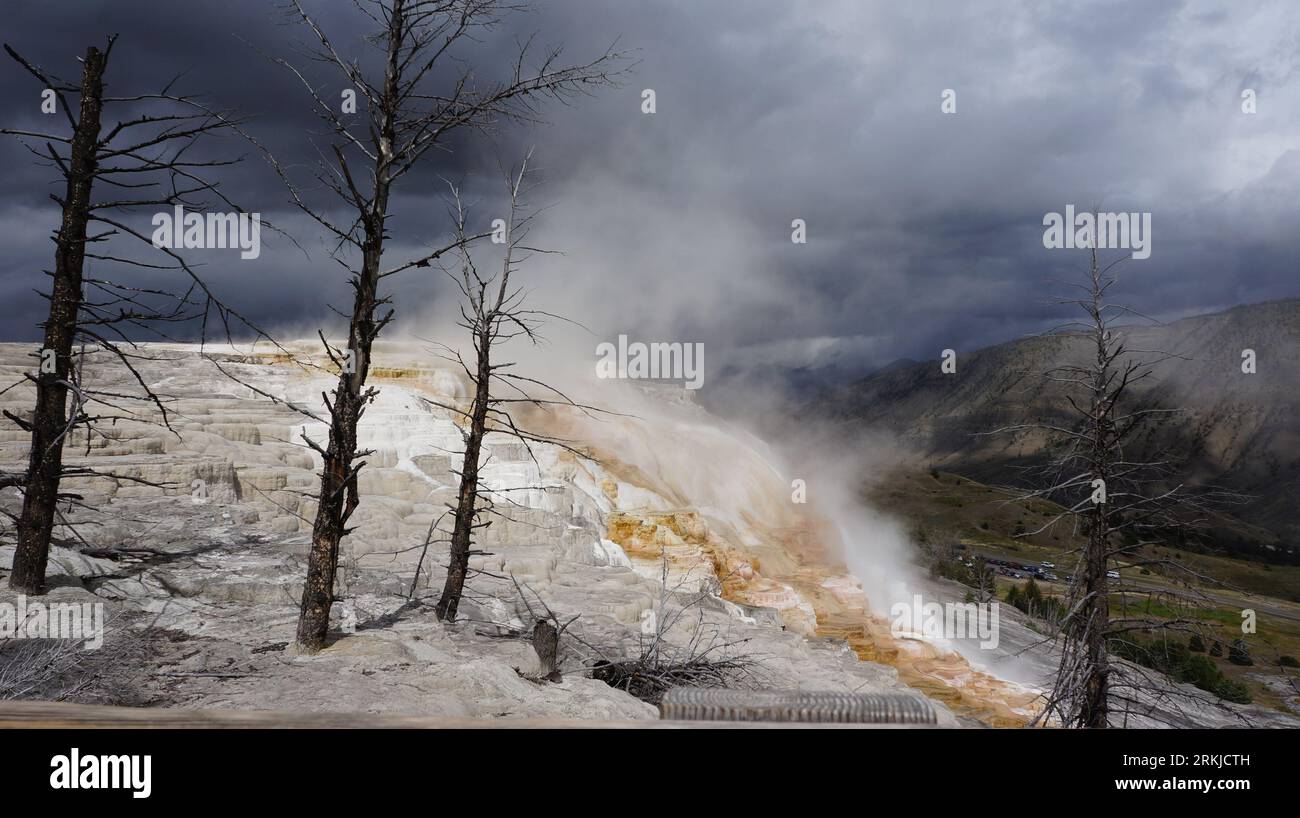 A majestic view of a hot spring surrounded by mountains with steam ...