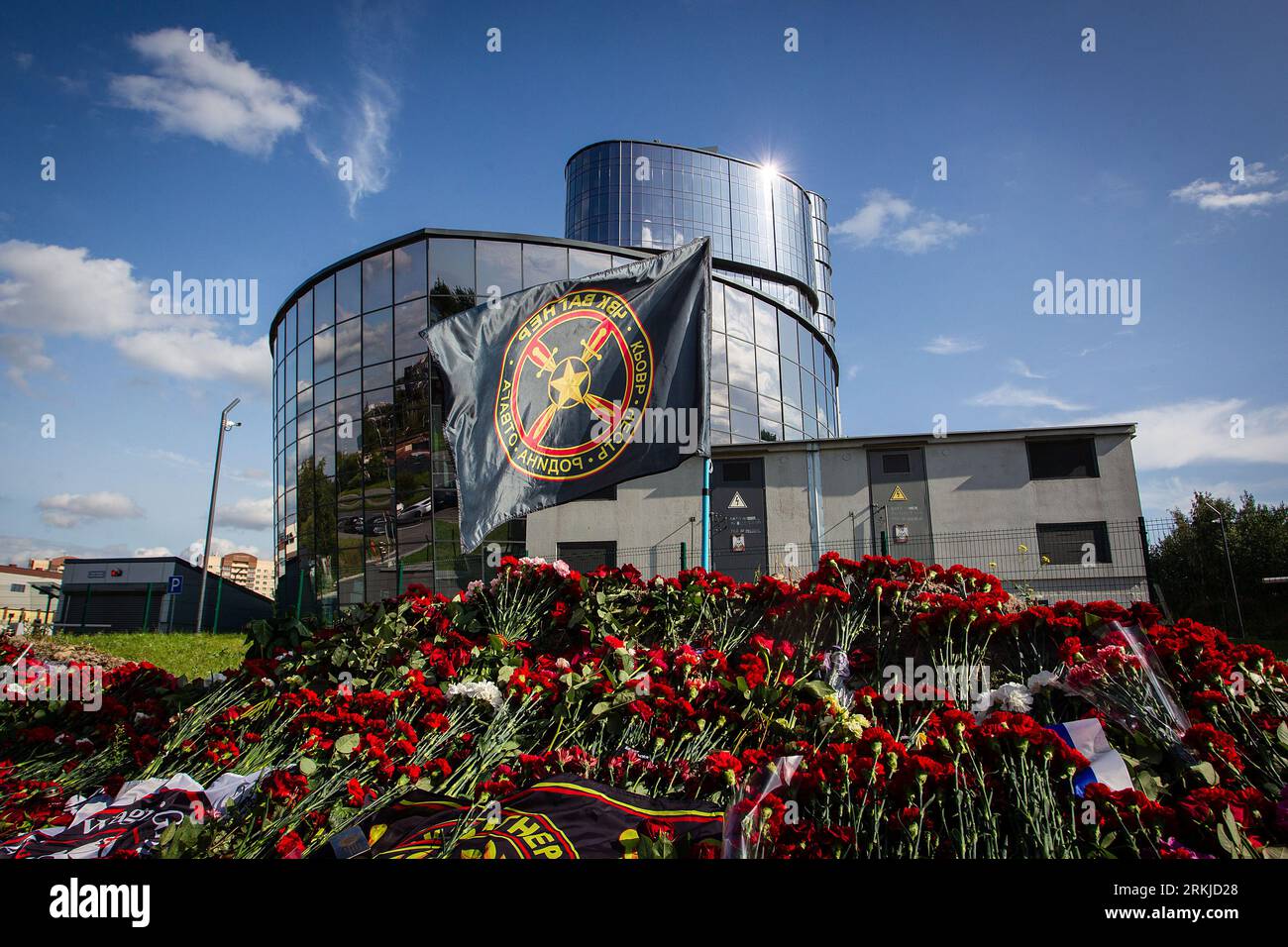 Flowers and a flag on top with the symbol of the PMC Wagner seen at a ...