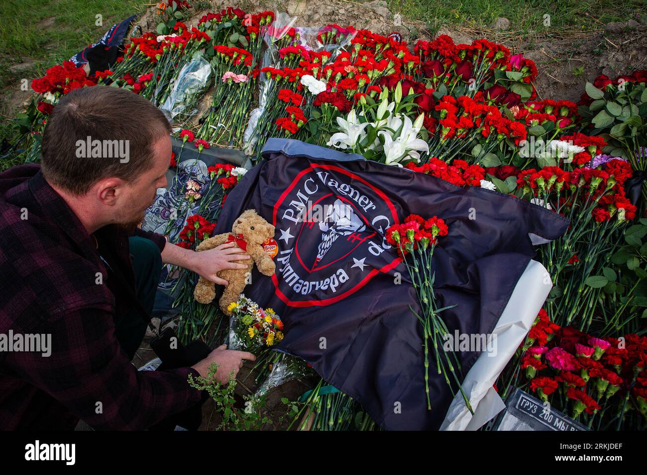 A man lays flowers in memory of Yevgeny Prigozhin at a spontaneous ...