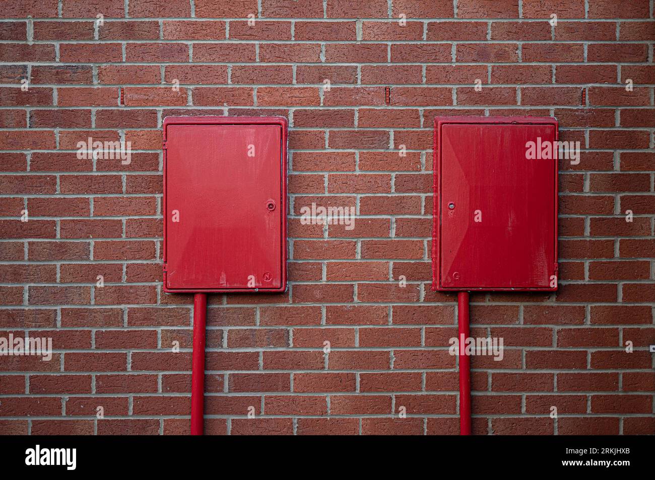 The two red square boxes affixed to a brick wall Stock Photo - Alamy
