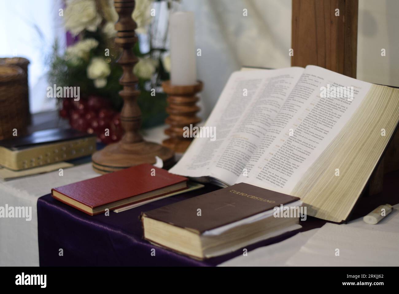 A Christian religious scene with a stack of Bible books on a table ...