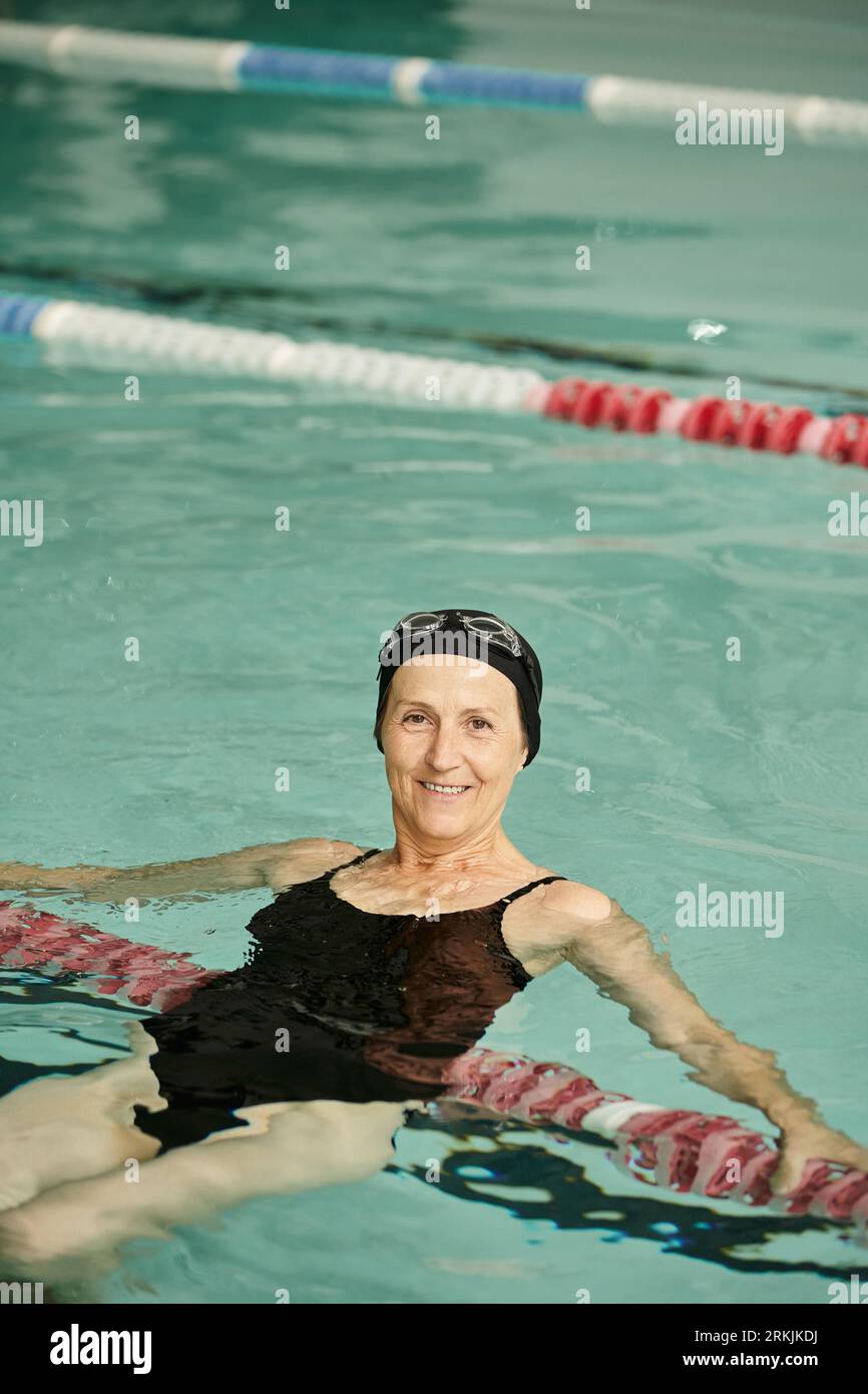 Cheerful And Fit Middle Aged Woman Swimming In Pool Swim Cap And