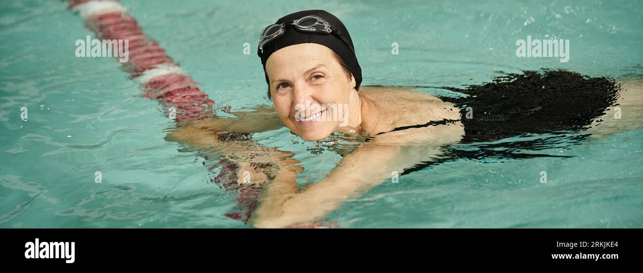 Positive Middle Aged Woman Swimming In Pool Swim Cap And Goggles