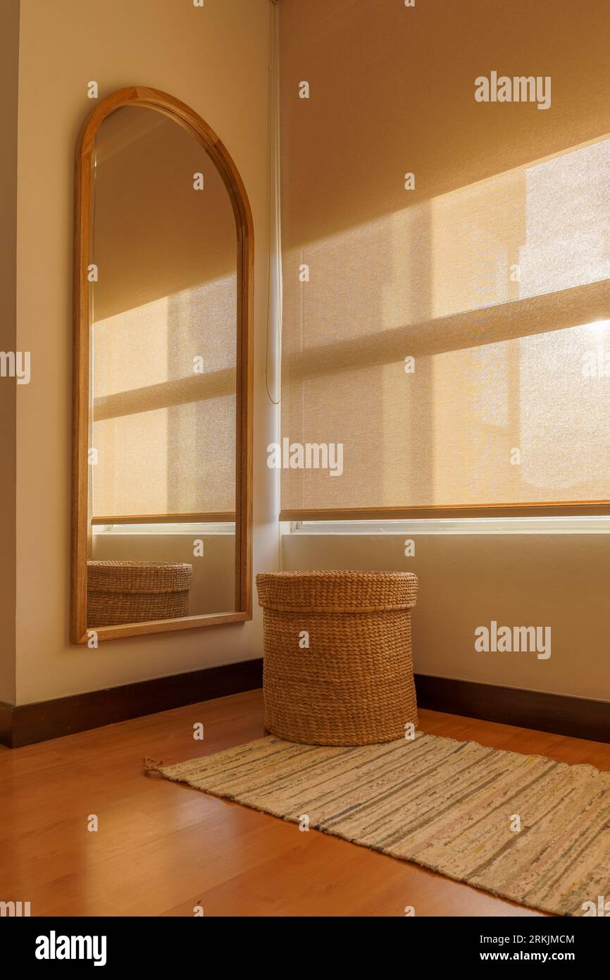 A mirror elegantly reflects the room's corner adorned with a window, a ...