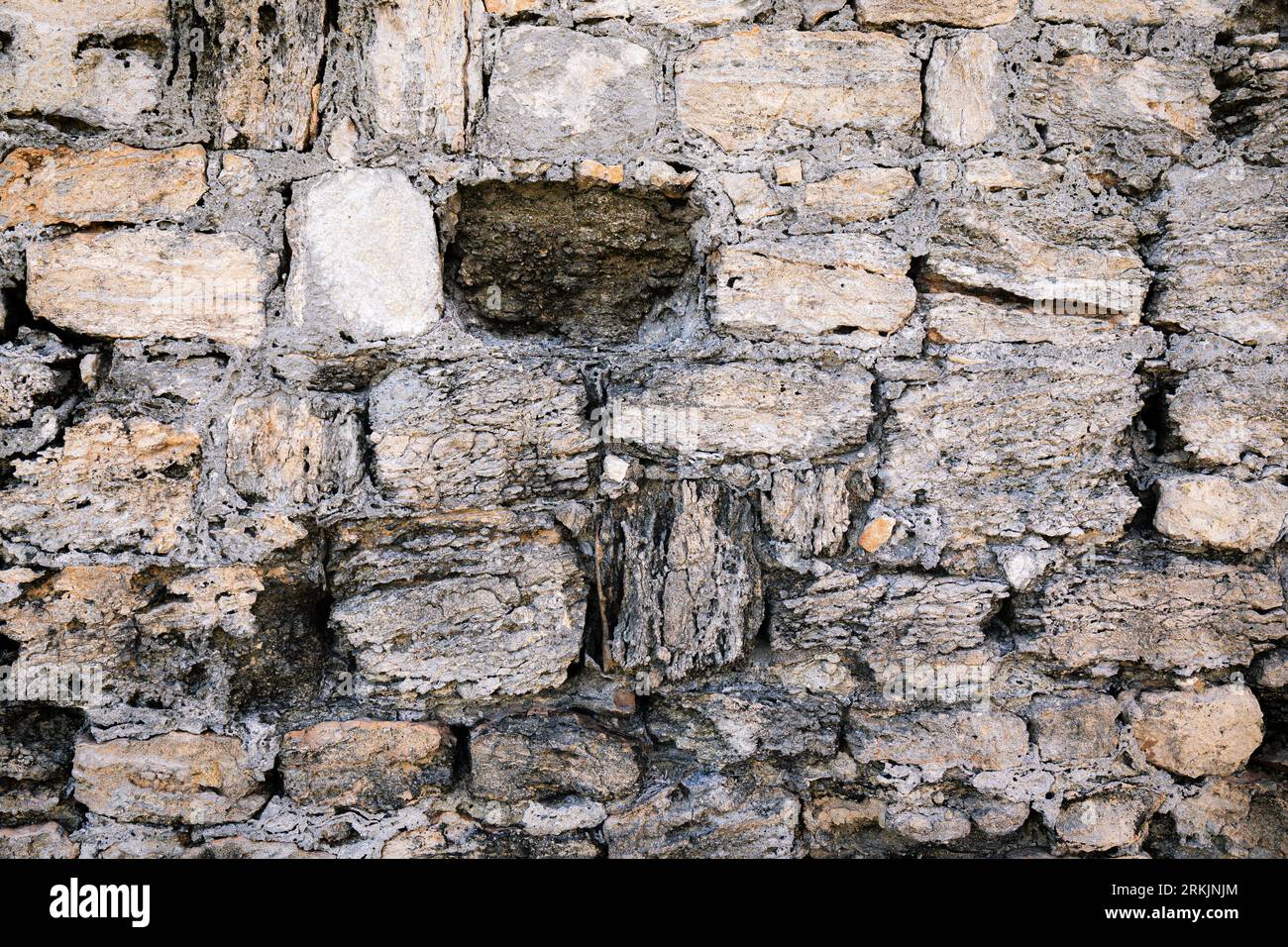 An old stone wall with multiple bricks blocking off a window Stock ...
