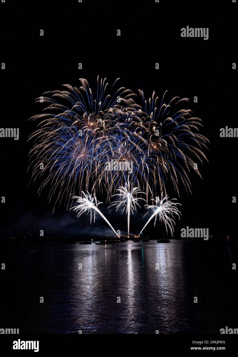 An aerial view of a lake inhabited by vibrant fireworks bursting in the ...