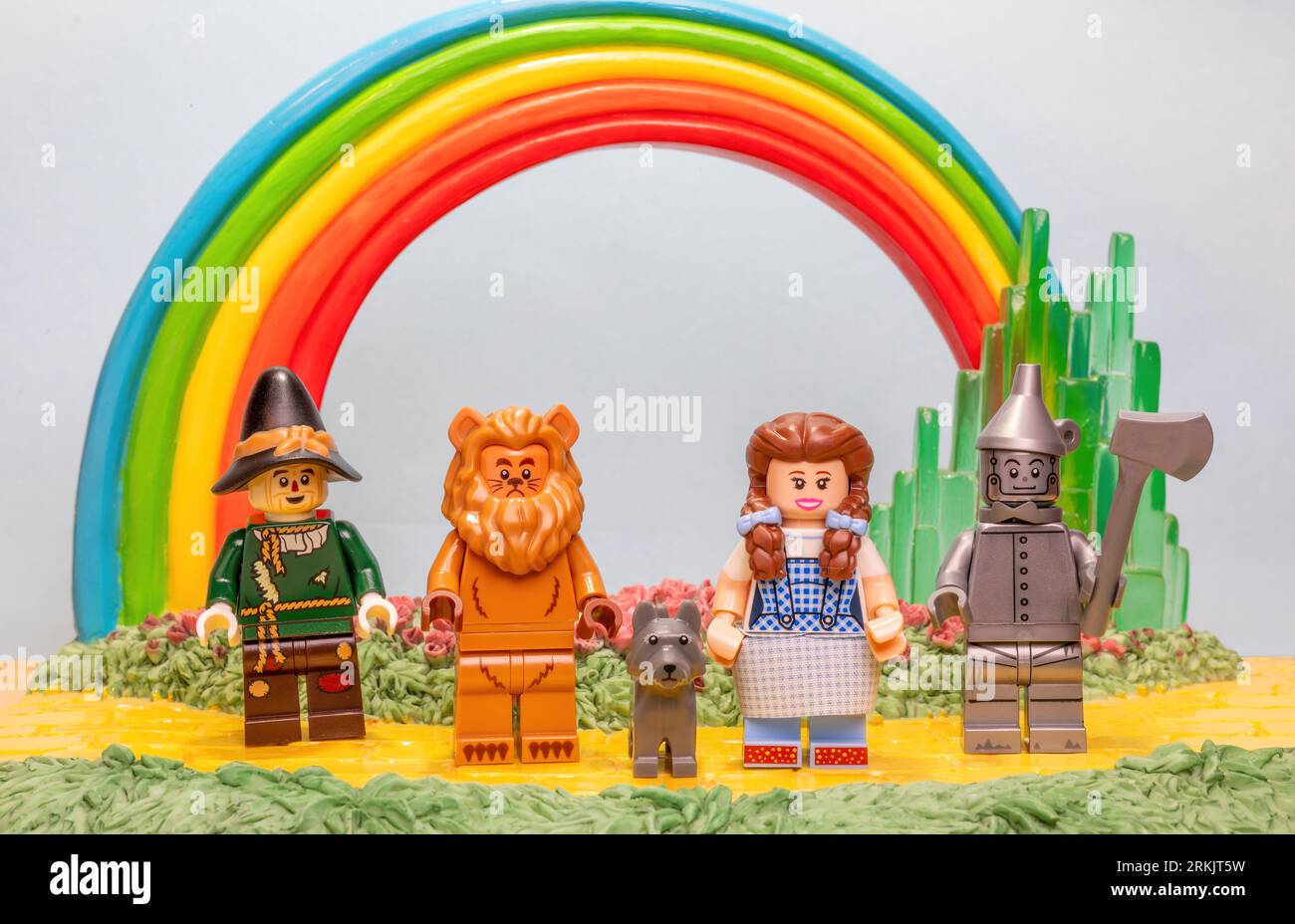 A group of three LEGO figures stand in a grassy field, illuminated by a ...