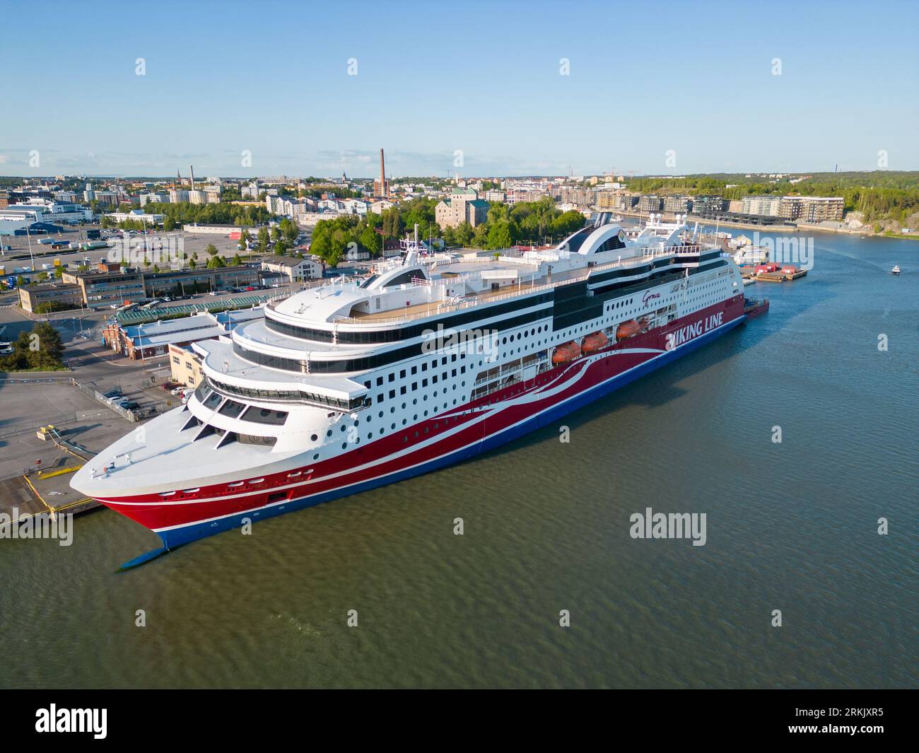 A luxurious cruise ship moored in a dock, its massive size creating an ...