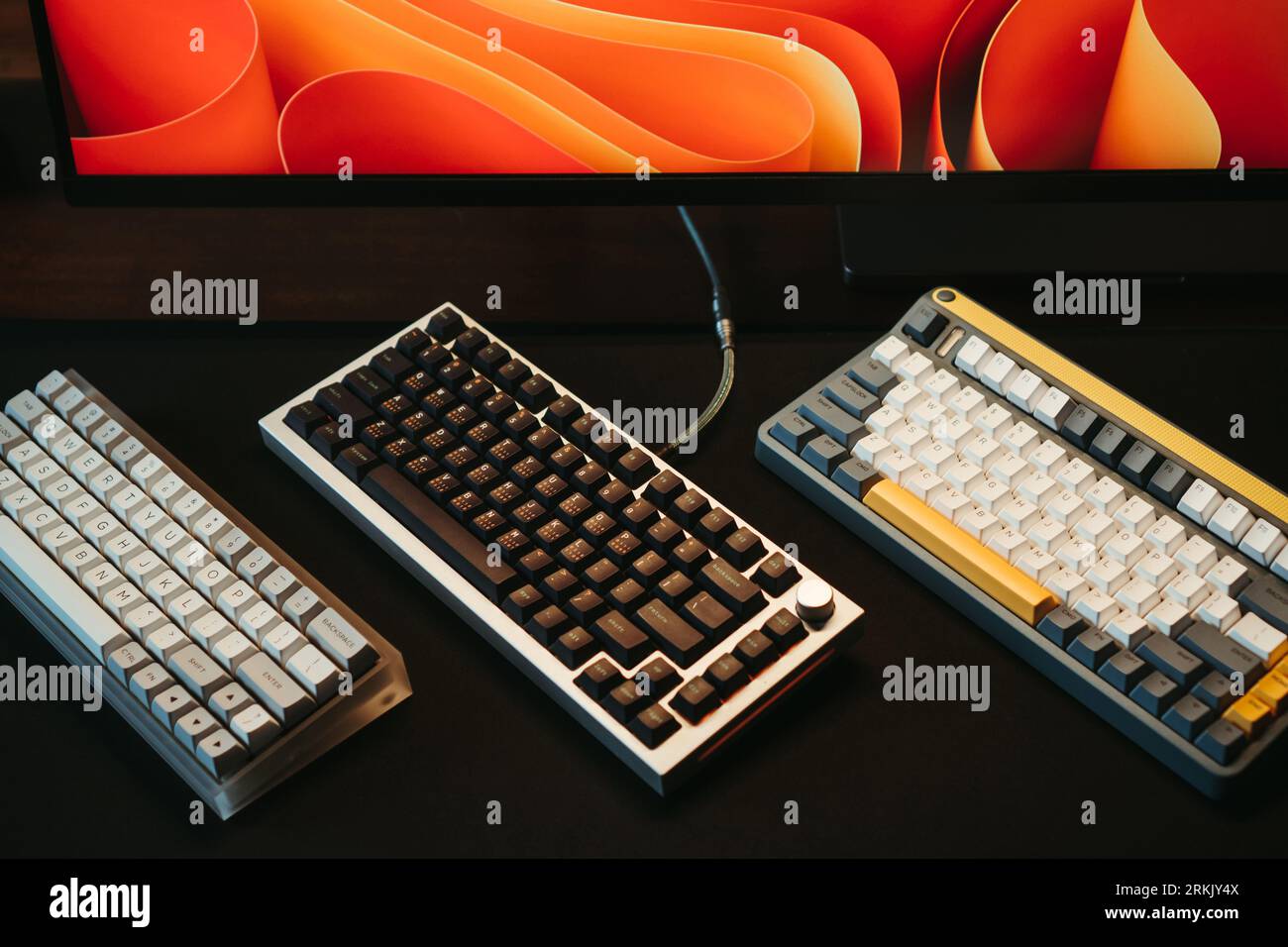 A computer with three different mechanical keyboards lying on the desk ...
