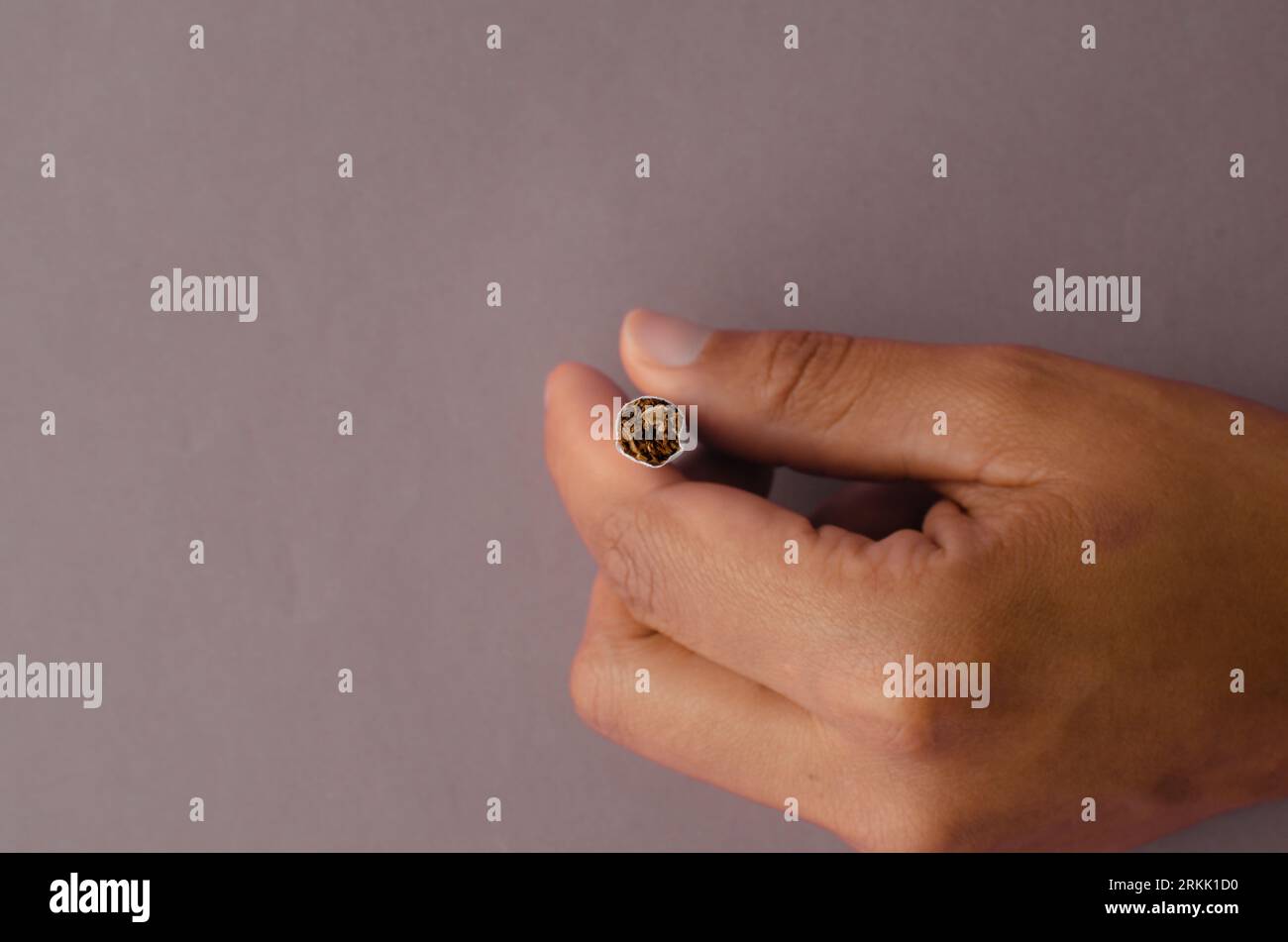 Close-up of a hand holding a cigarette with visible tobacco ...