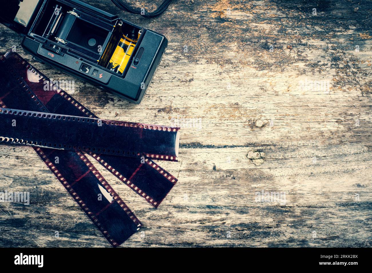 Manual old camera and film used to strip on an old wooden background ...