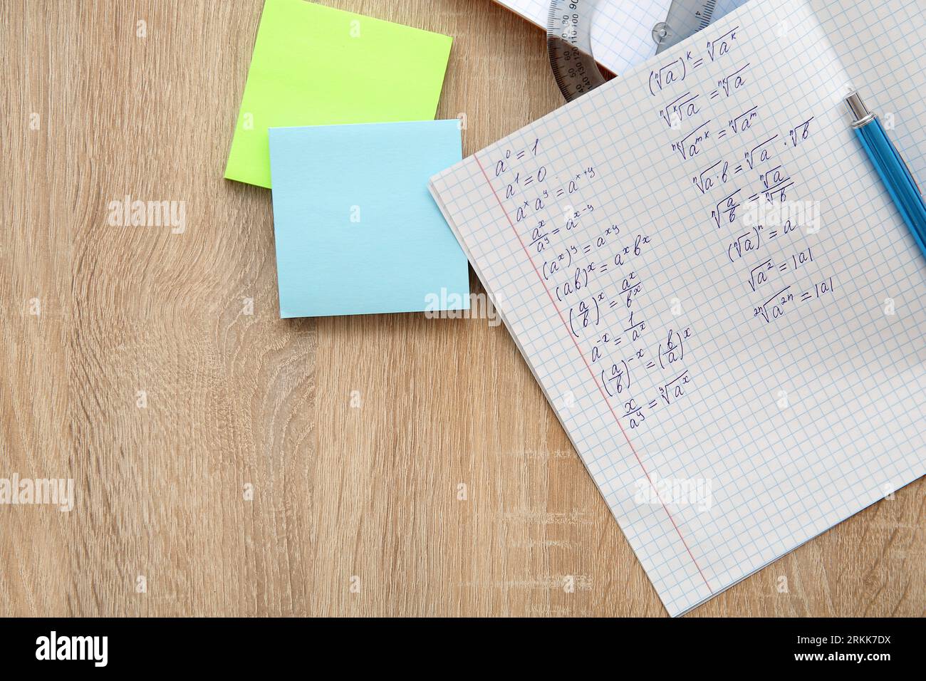 Open copybook with math formulas on wooden table Stock Photo - Alamy