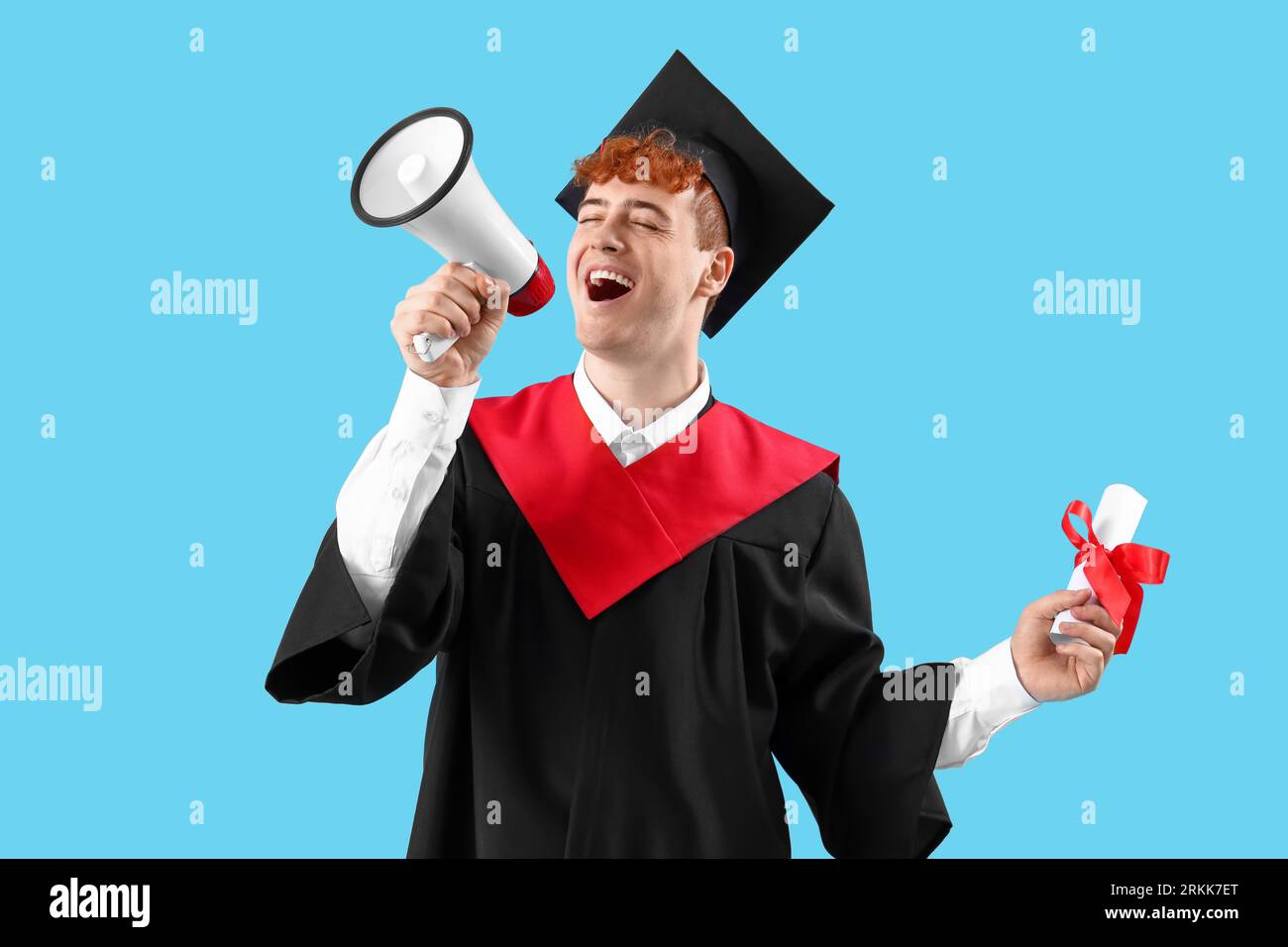 Male graduate student with diploma shouting into megaphone on blue ...