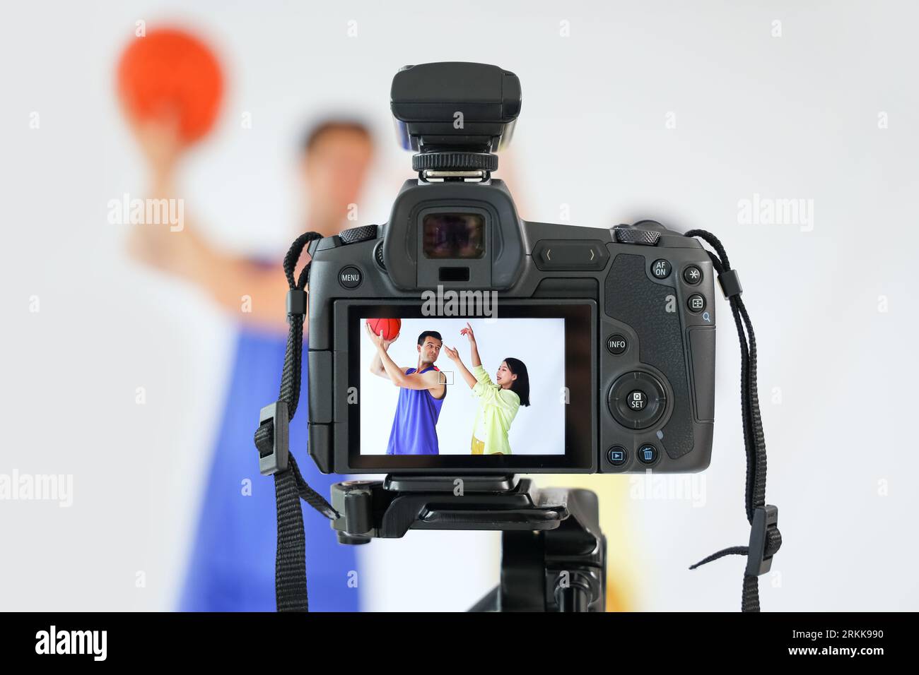 Female photographer working with basketball player on camera screen in ...