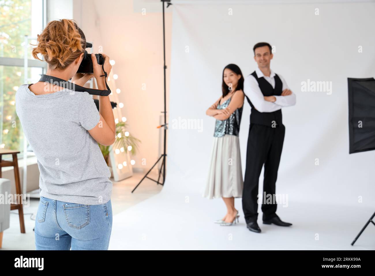 Female photographer taking picture of young couple in studio Stock ...