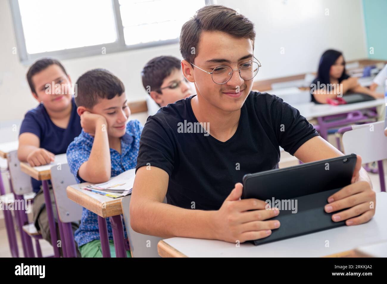 Teenager using the tablet in school and have a smile on his face Stock ...