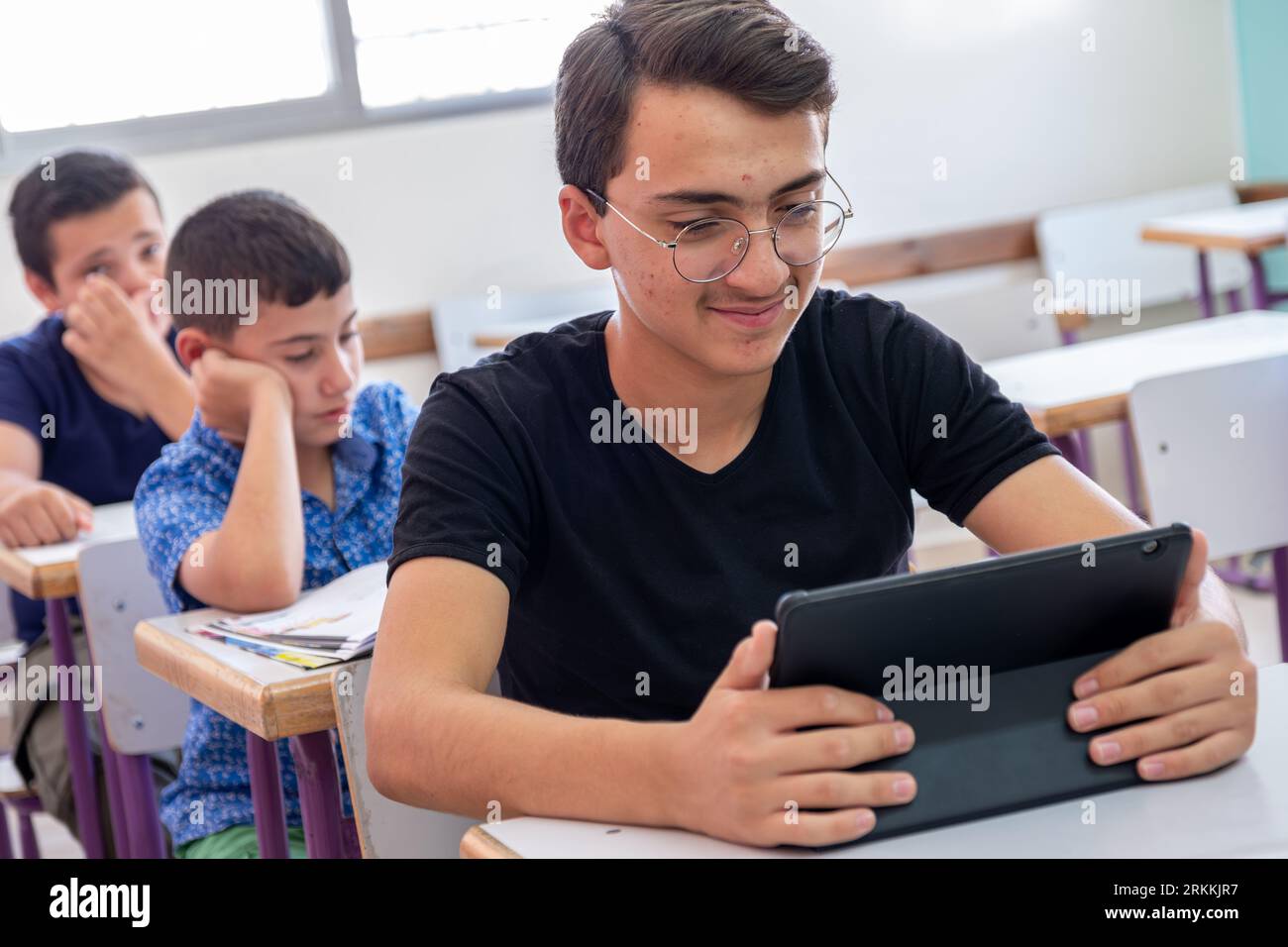 Teenager using the tablet in school and have a smile on his face Stock ...