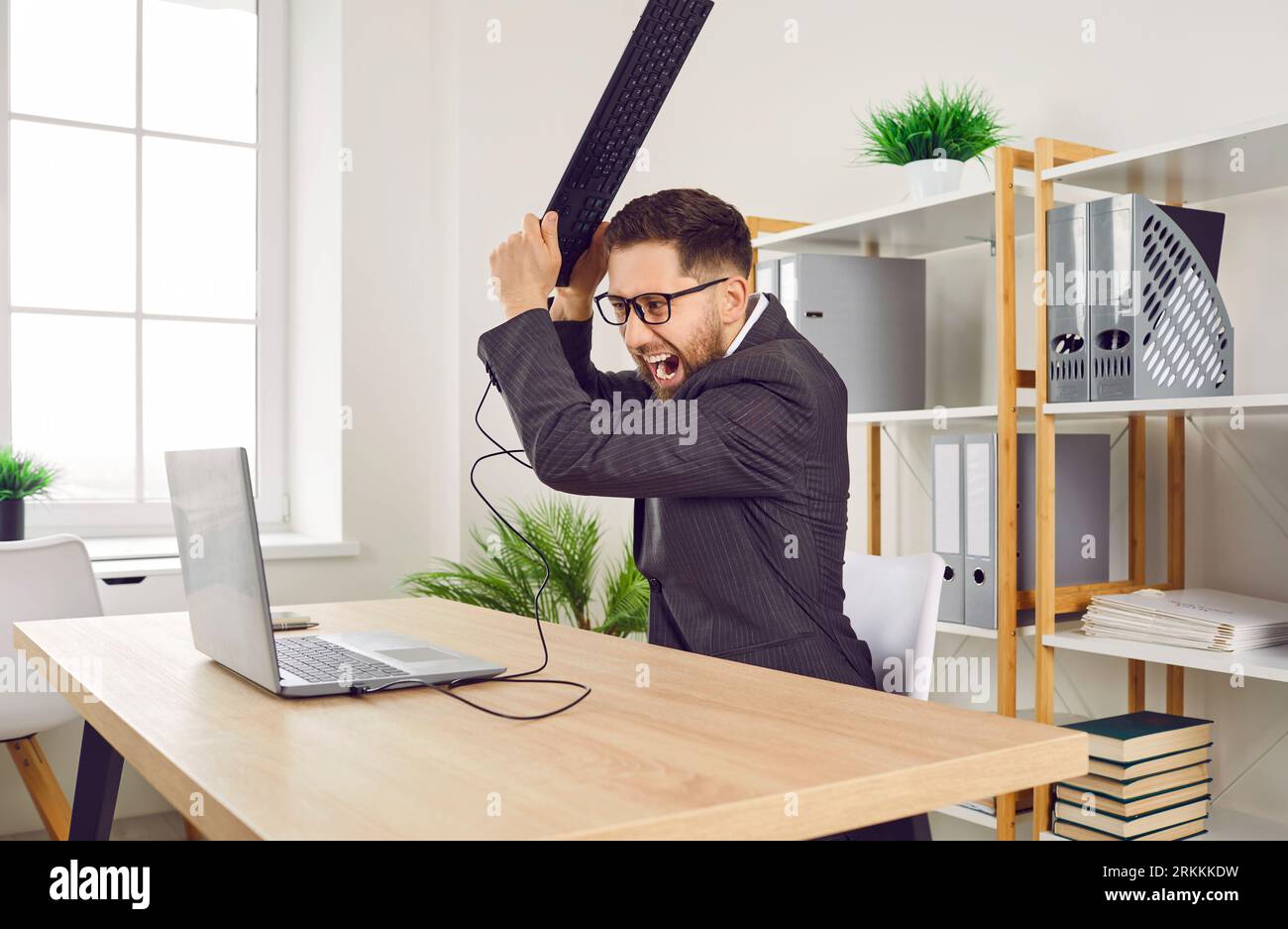 Office worker gets angry at computer because of error and wants to ...