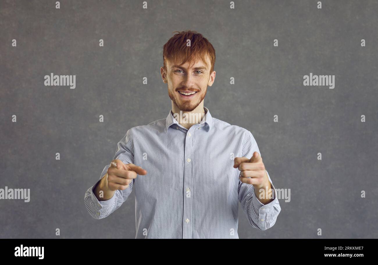 Positive smiling man pointing his index fingers directly at the camera ...