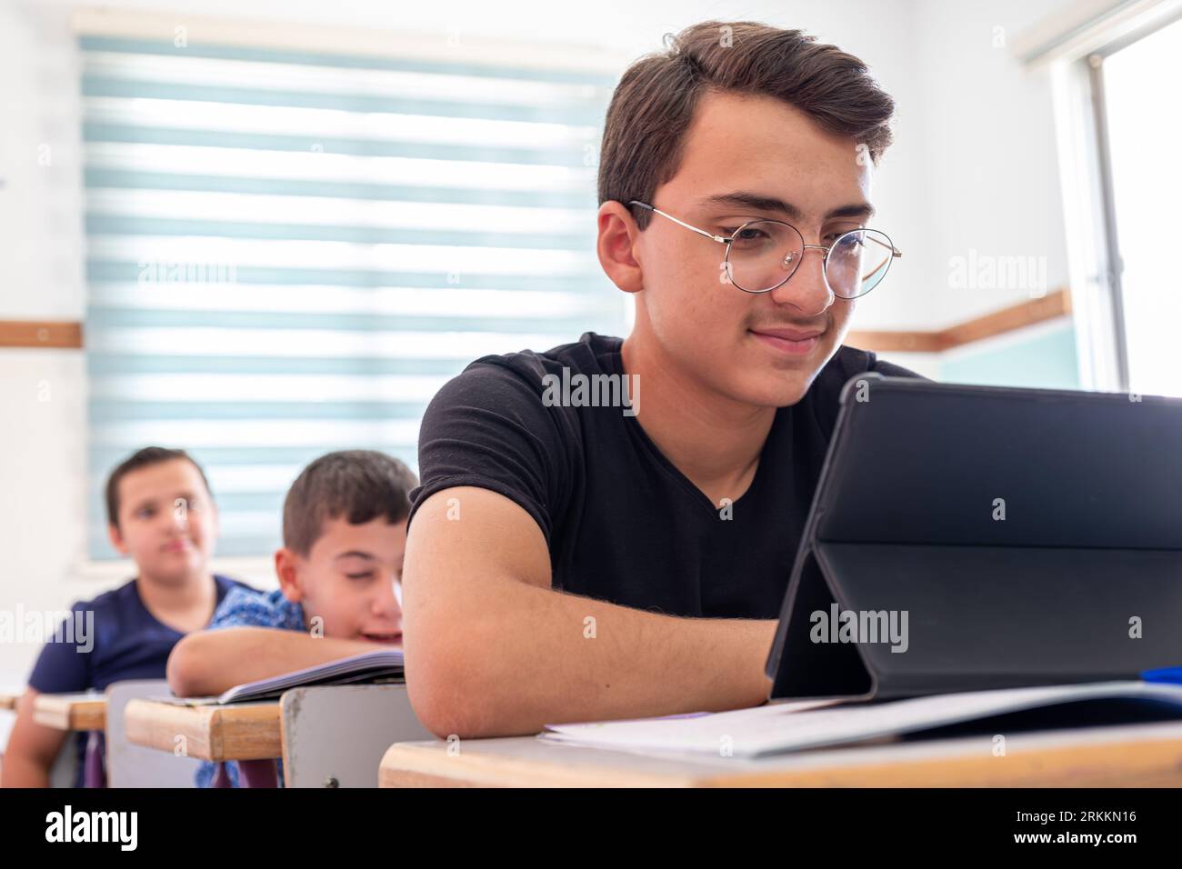 Teenager using the tablet in school and have a smile on his face Stock ...