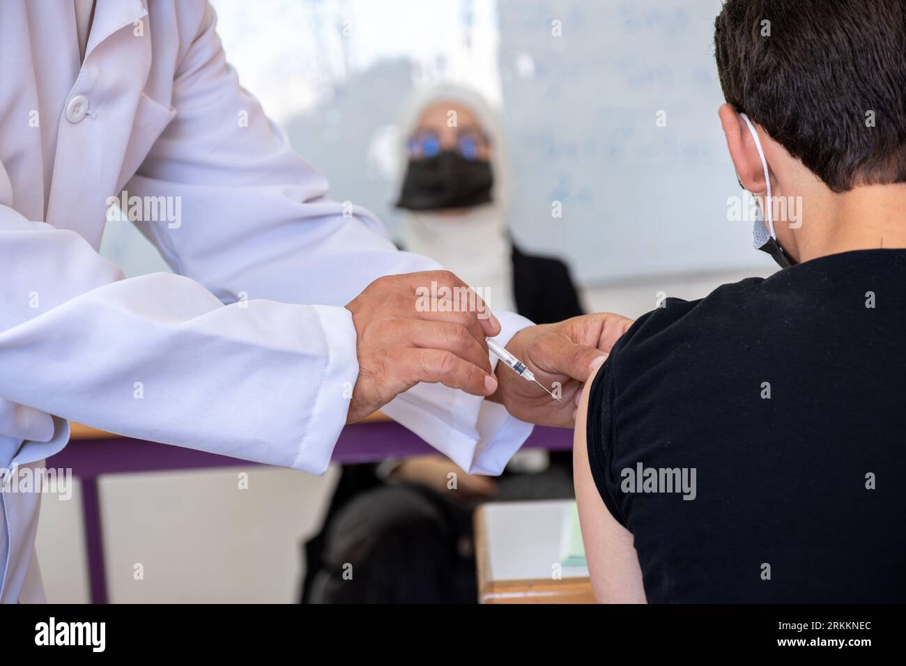 Doctor providing vaccine to the students in the classroom Stock Photo ...