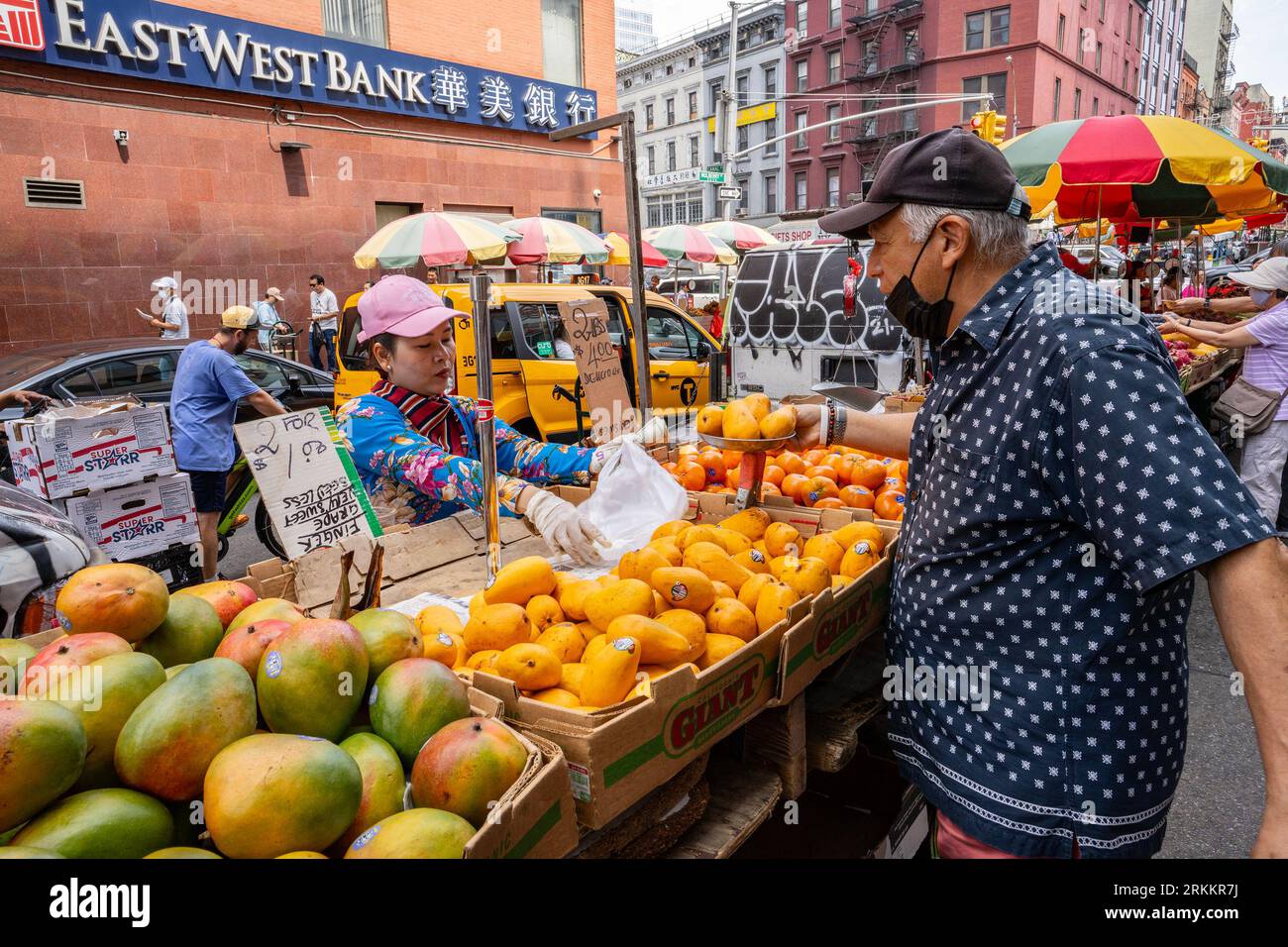 New York, USA - July 20th, 2023: A man buying mangos in a street market ...