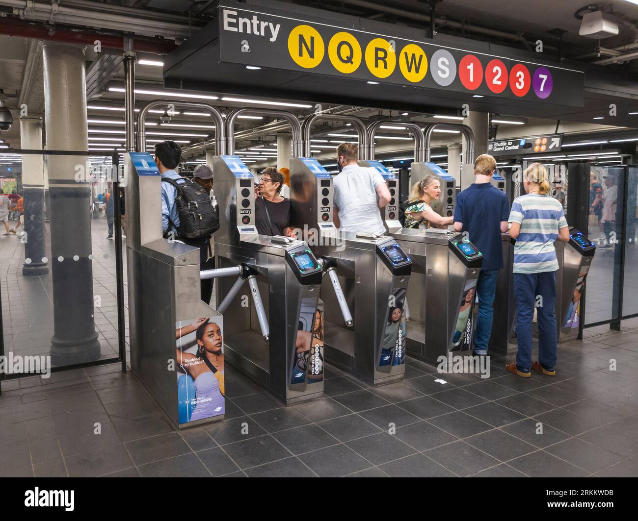 Weekday riders enter the Times Square station in the New York subway on ...
