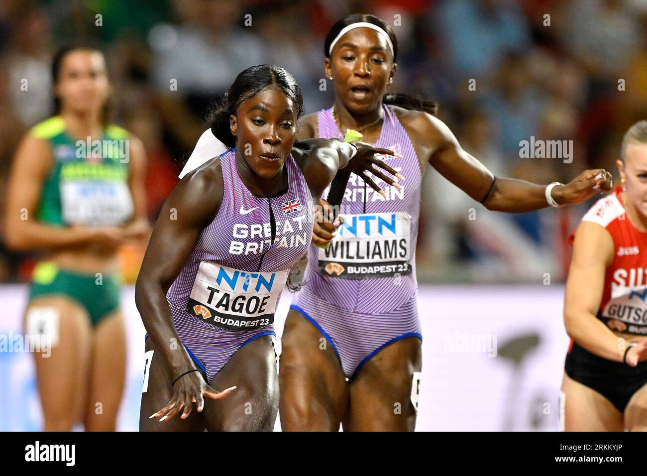 Annie Tagoe, second from left, of Great Britain, takes the baton from ...