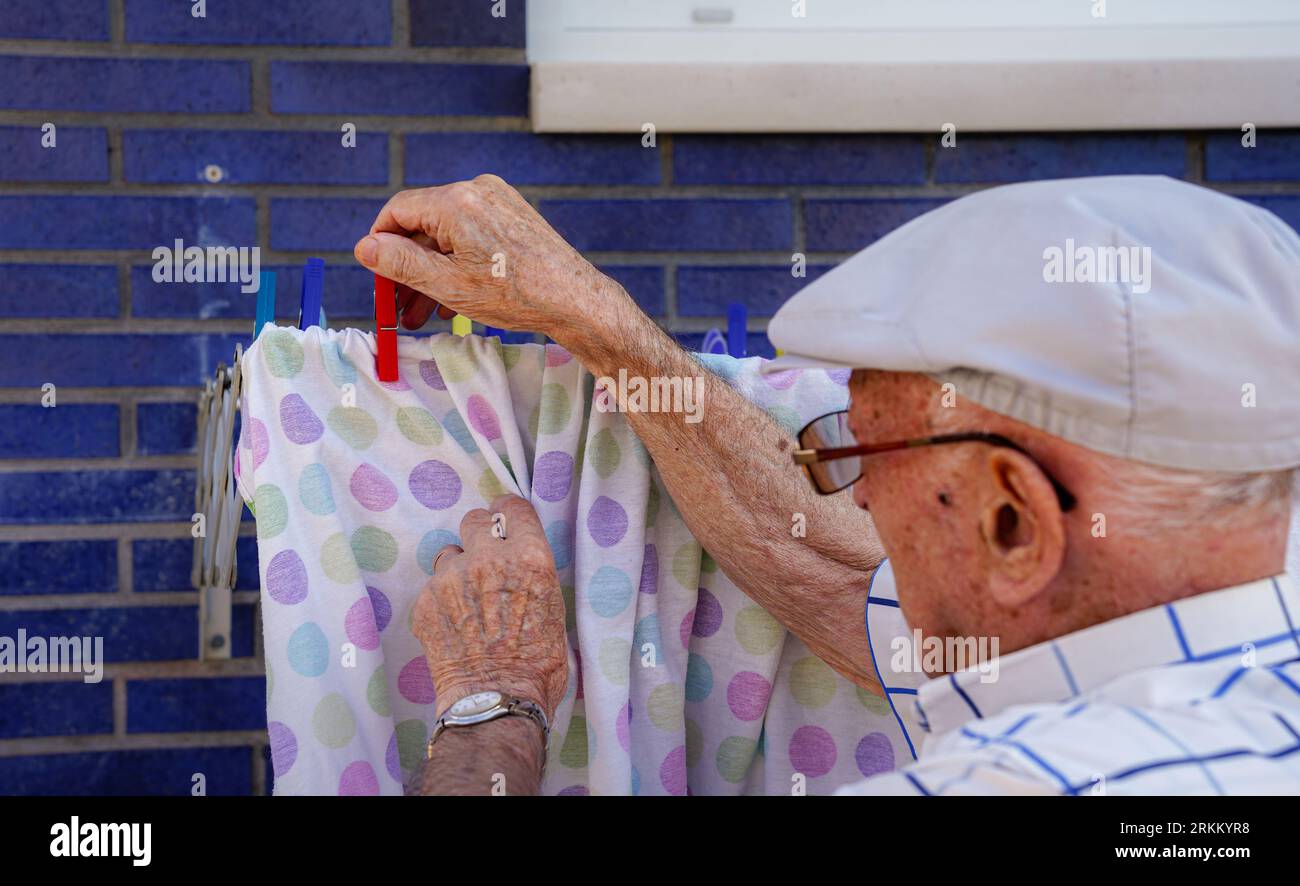 an older man hanging up the laundry. household chores done by men ...