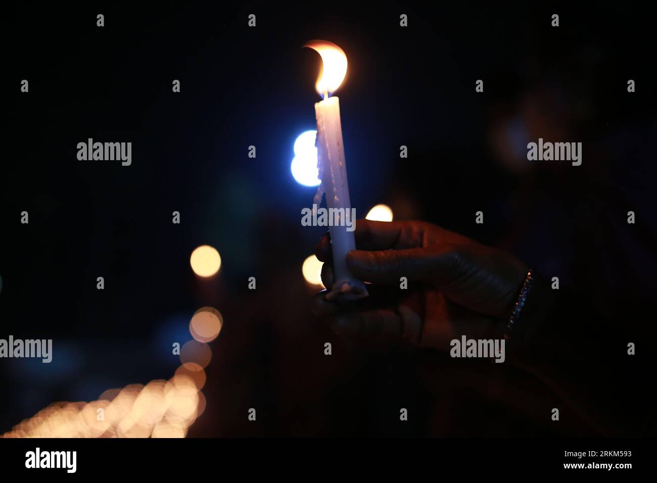 DHAKA, BANGLADESH-MARCH 8, 2021: A woman holds candle as she take part ...