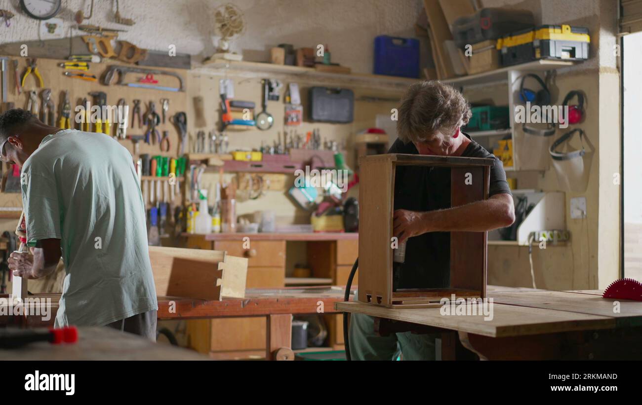 Carpentry shop scene of two carpenters working with tools to build and ...