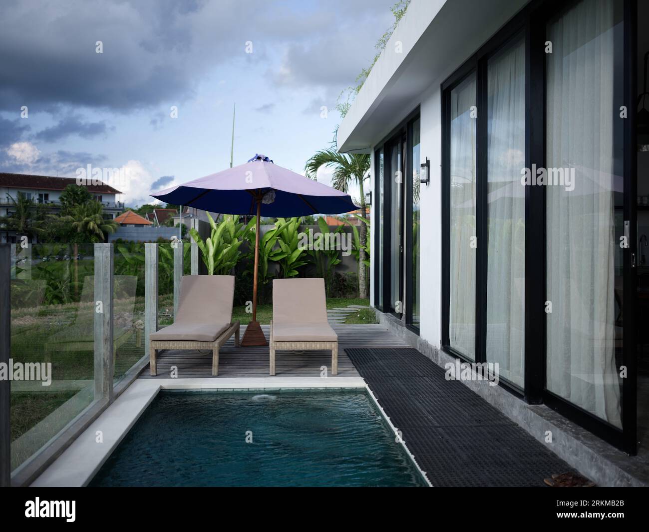 Modern villa in Bali with swimming pool and sunbeds overlooking the ...