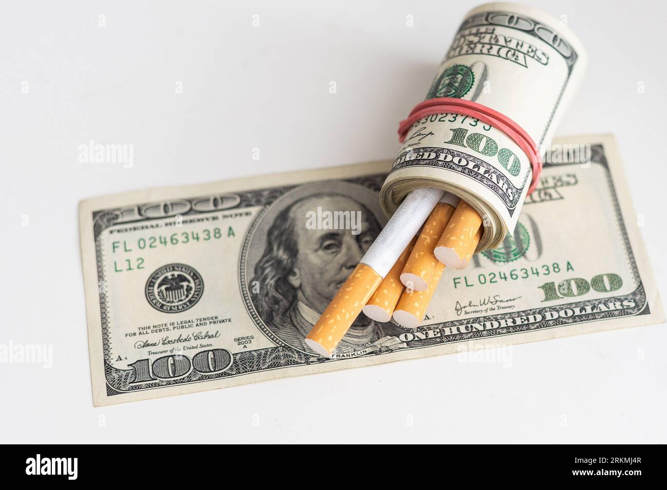 cigarettes and money. expensive habit. white background - horizontal ...