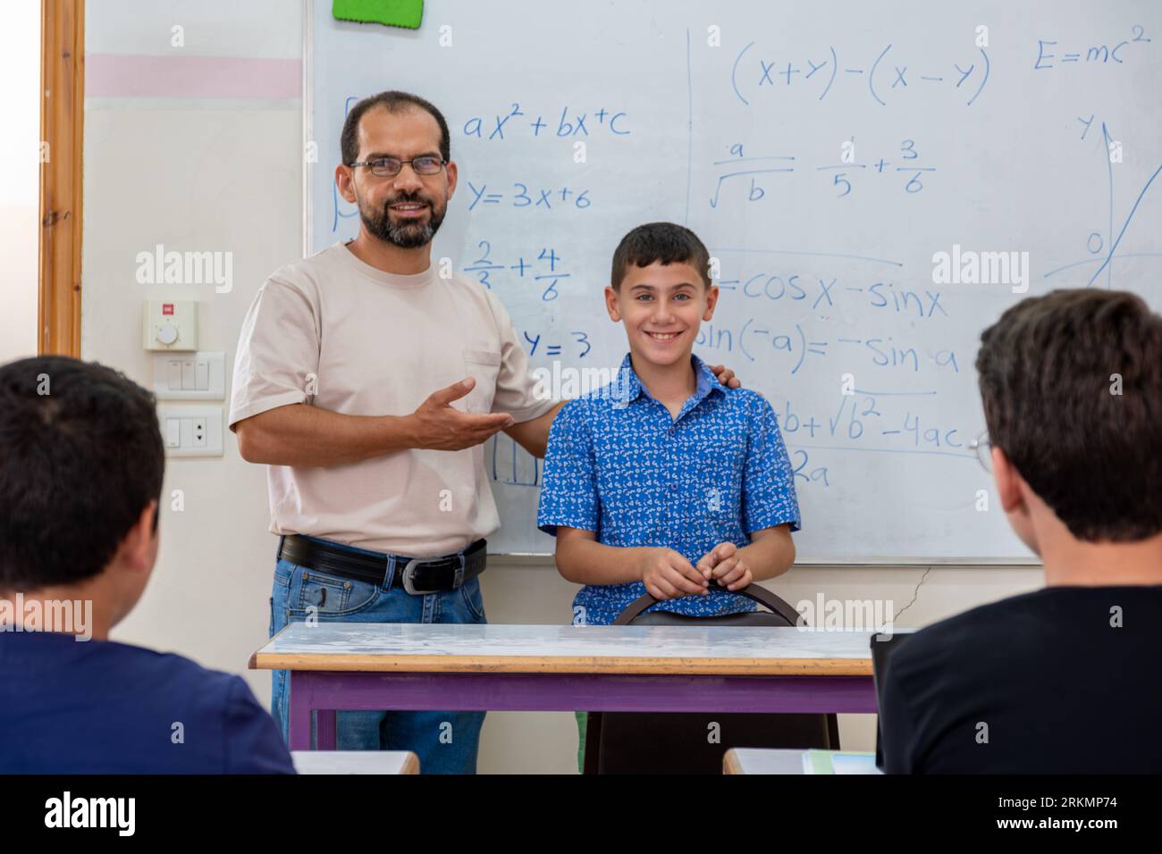 Teacher with his best student in class room Stock Photo - Alamy