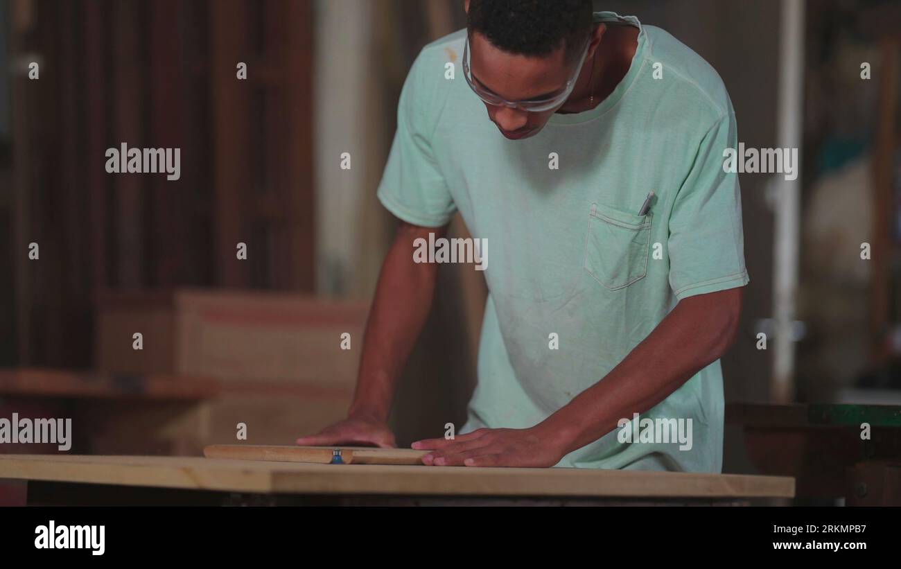 One young black Brazilian carpenter working at carpentry workshop ...